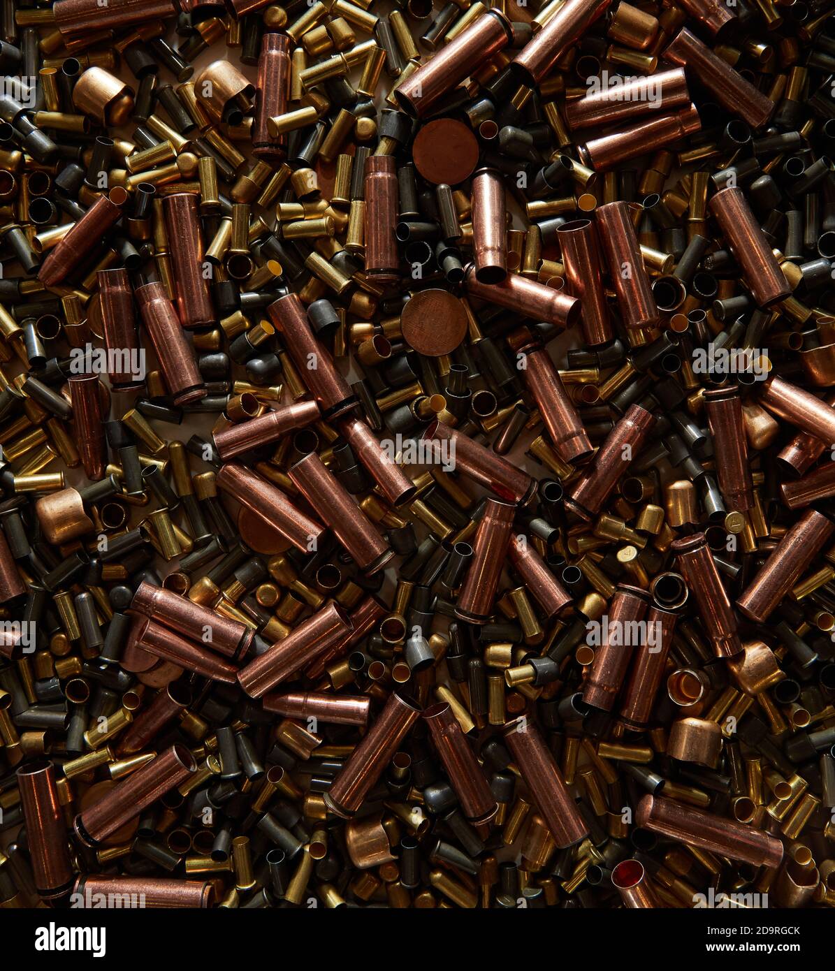 Different size bullet shells on the black ground. War concept ...