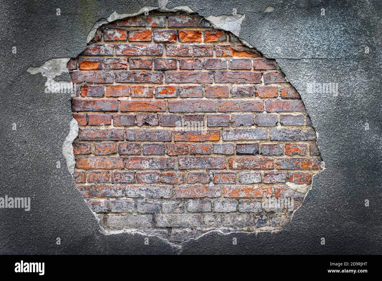 Rustic red corroded brick hole in a grey plaster wall. High quality ...