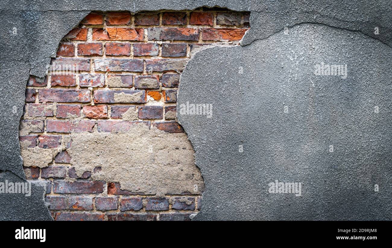 Rustic red corroded brick hole in a grey plaster wall. High quality ...