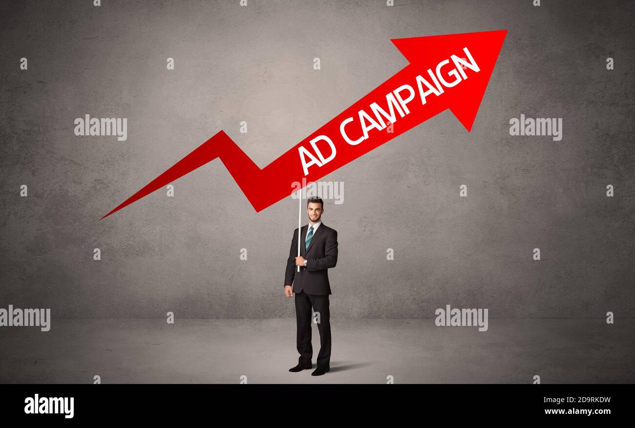 Young business person in casual holding road sign with AD CAMPAIGN ...