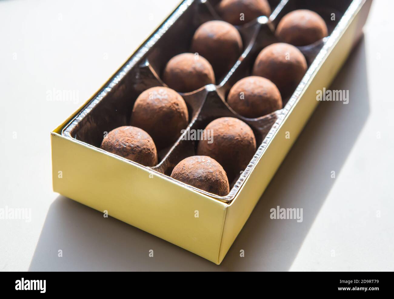 Chocolate sweets with truffle filling in a cardboard box. Isolated ...