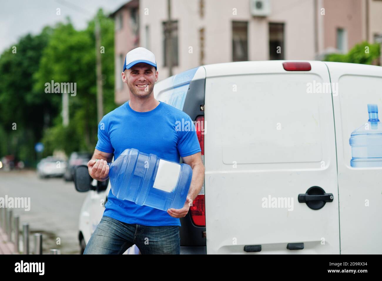 Delivery men in front cargo van delivering bottles of water Stock Photo ...