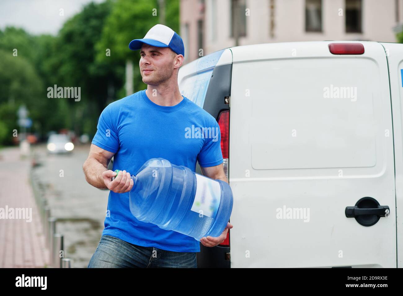Delivery men in front cargo van delivering bottles of water Stock Photo ...