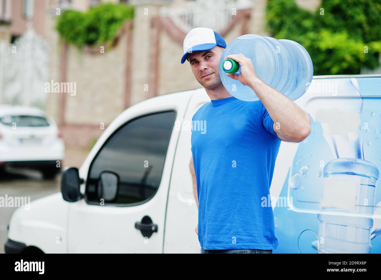 Delivery man in front cargo van delivering bottles of water Stock Photo ...