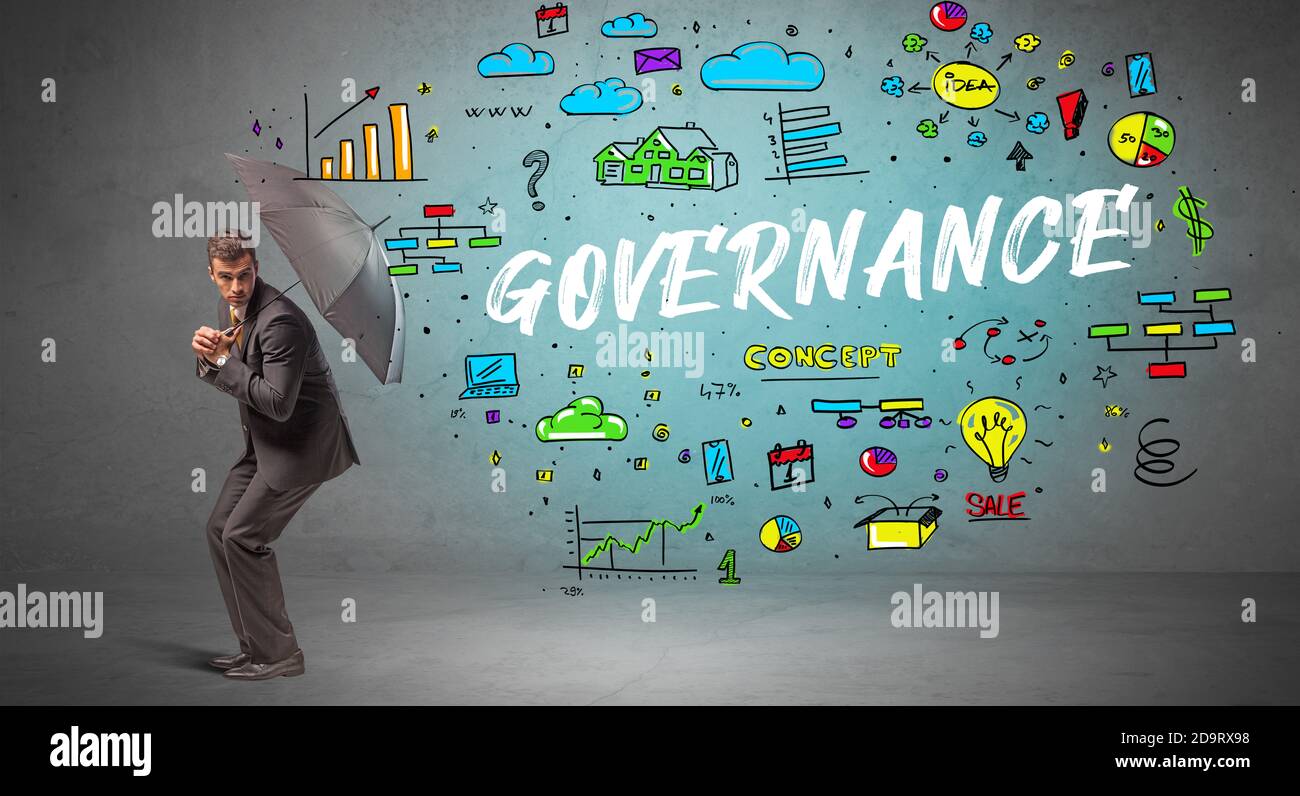 Determined businessman hiding behind umbrella with GOVERNANCE ...