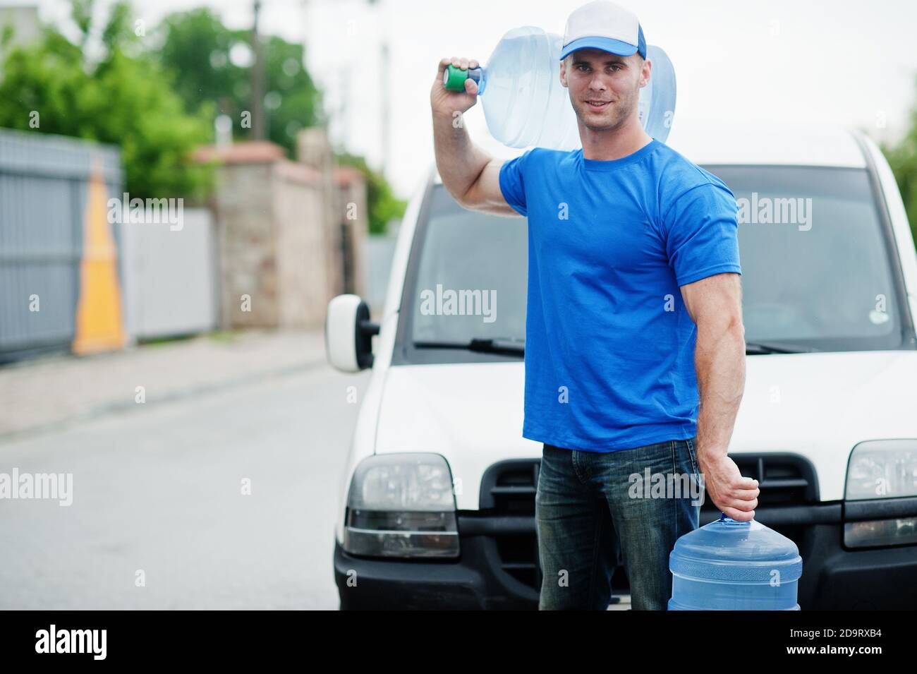 Delivery man in front cargo van delivering bottles of water Stock Photo ...