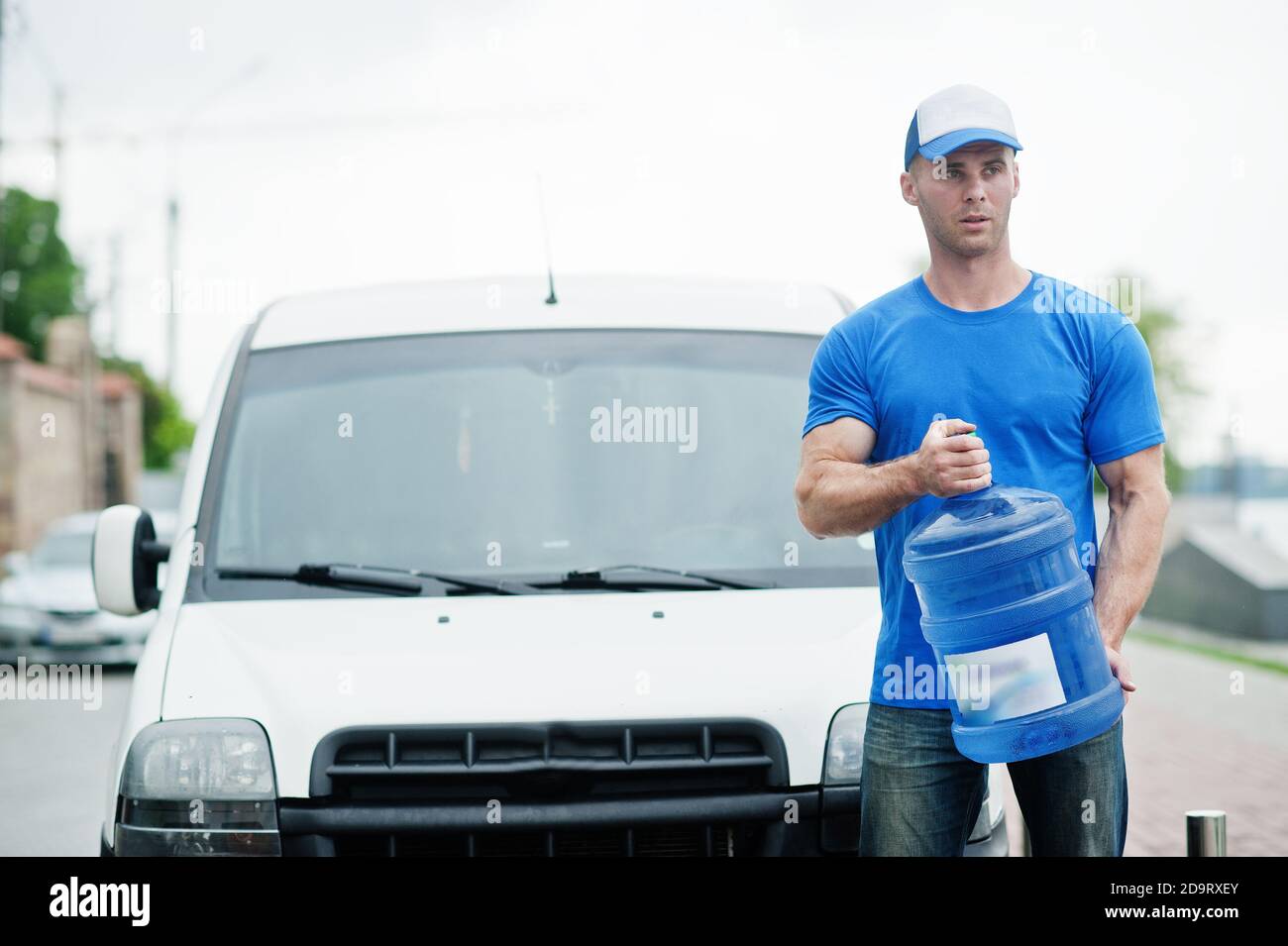 Delivery man in front cargo van delivering bottles of water Stock Photo ...