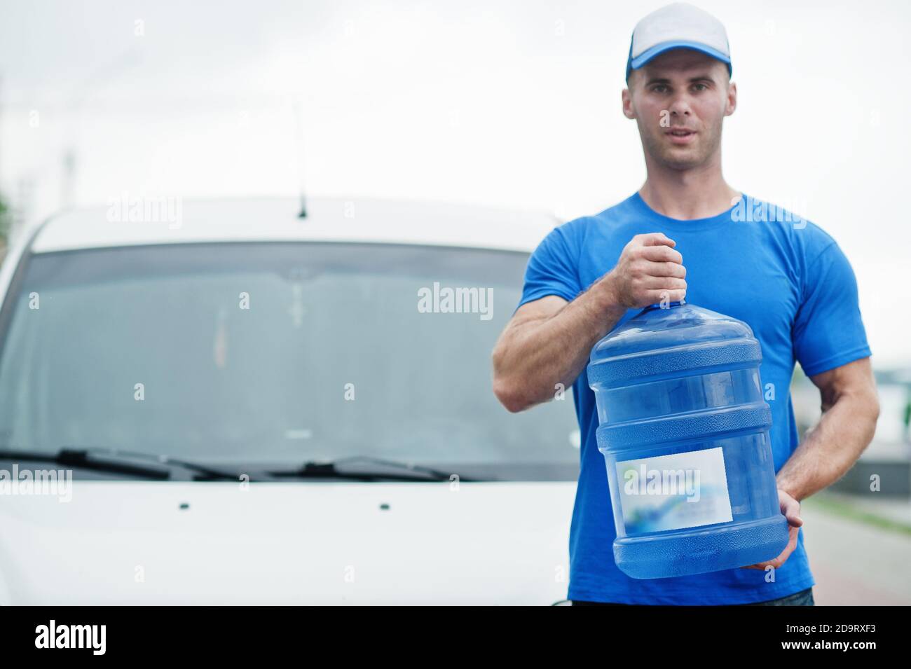 Delivery man in front cargo van delivering bottles of water Stock Photo ...