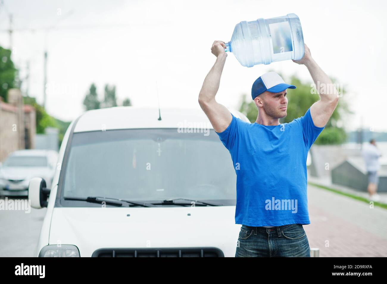 Delivery man in front cargo van delivering bottles of water Stock Photo ...