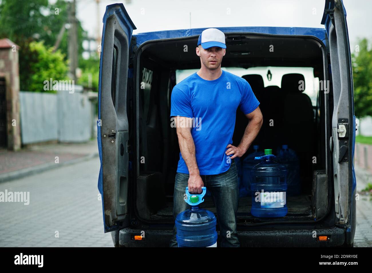 Delivery man in front cargo van delivering bottles of water Stock Photo ...