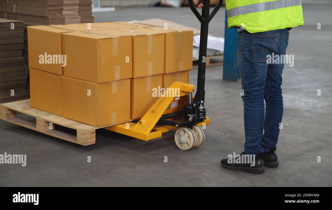 Factory workers deliver boxes package on a pushing trolley in the ...