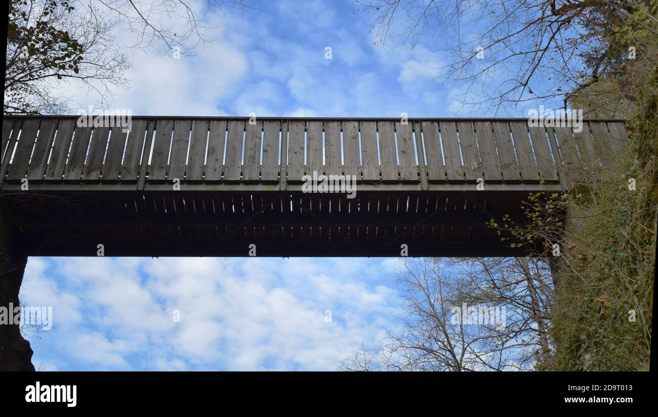 Old wooden bridge seen from below vantage point against a high contrast ...