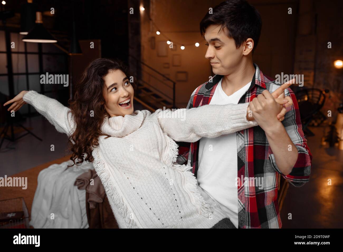 Funny young couple having fun together and enjoying family cozy moments ...