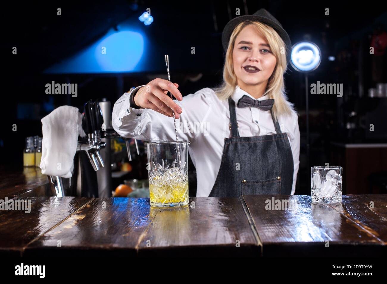 Professional woman mixologist creates a cocktail while standing near ...