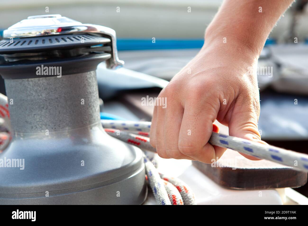 Mans hand pulling winch rope on sailing boat Stock Photo - Alamy