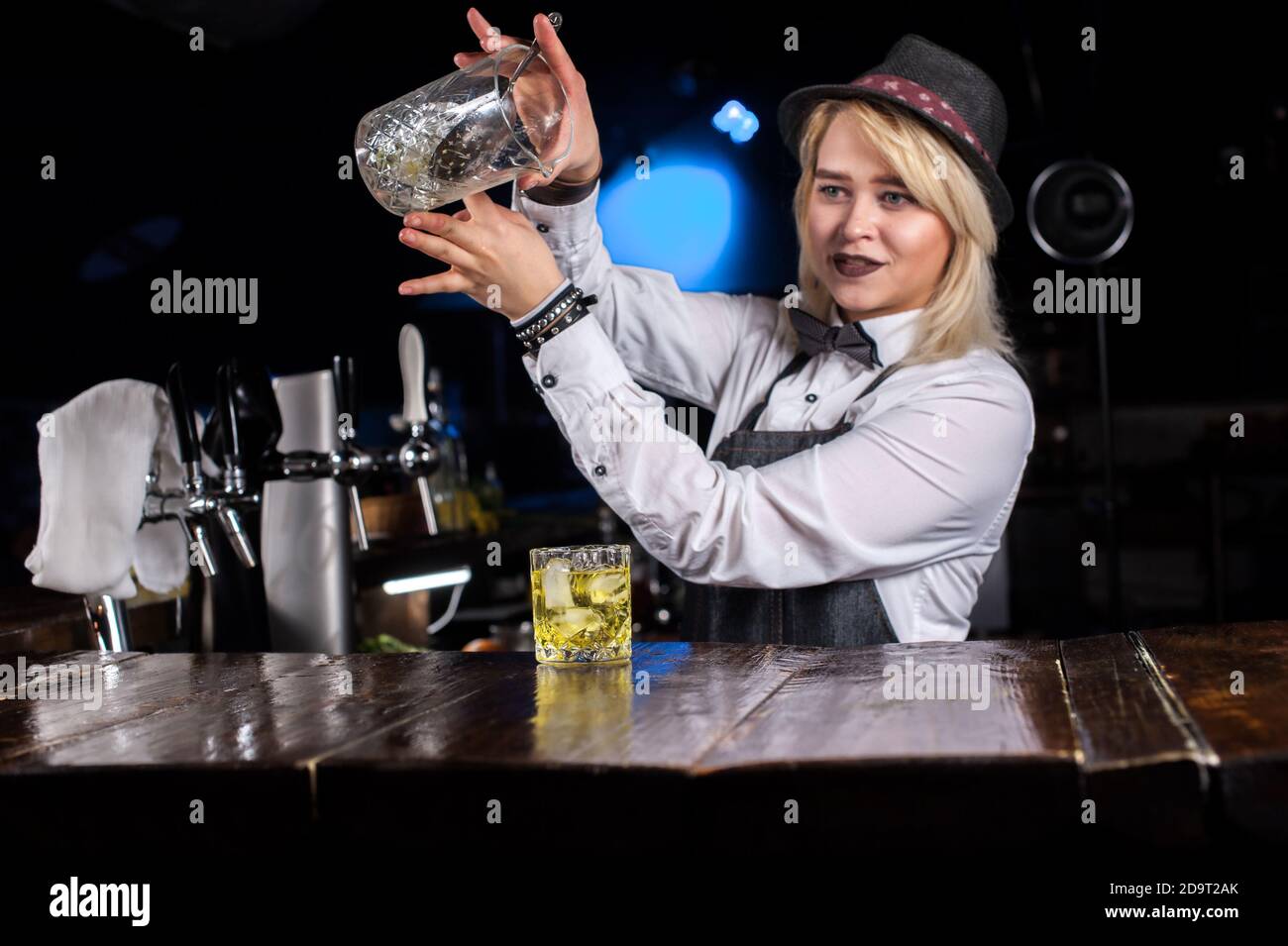 Pretty girl bartending adds ingredients to a cocktail behind bar Stock ...