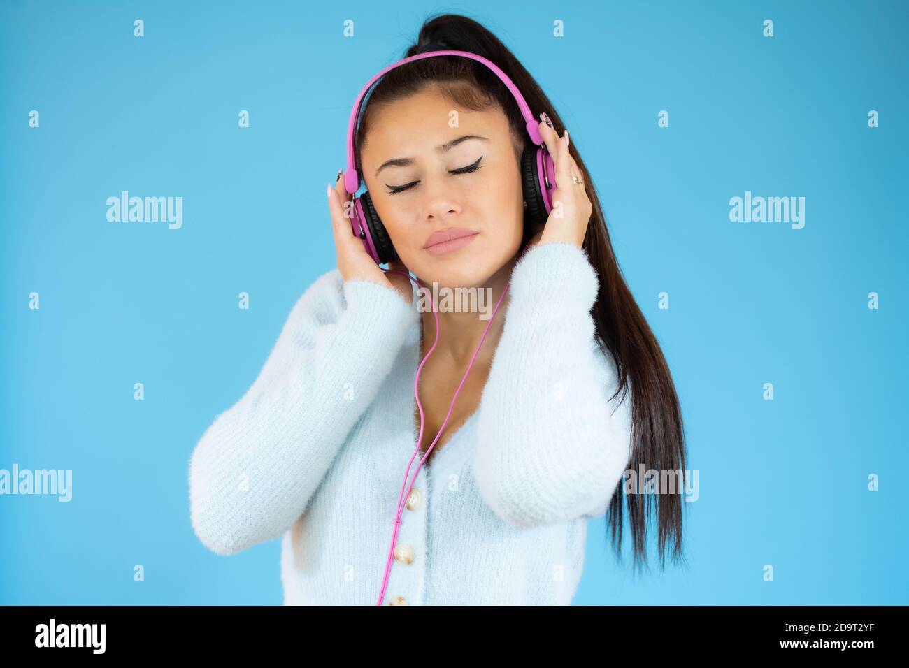 Closed up portrait of young woman wearing casual sweater listening ...