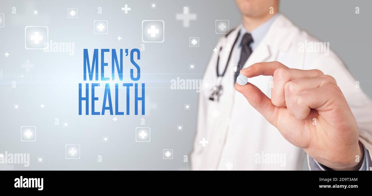 Close-up of a doctor giving a pill with MEN’S HEALTH inscription ...