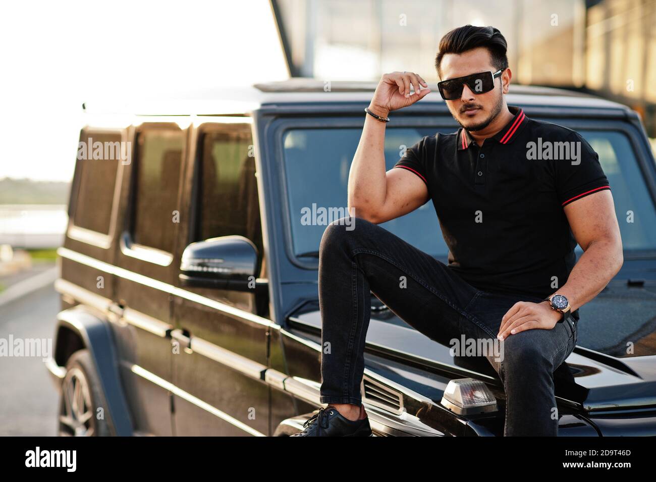 Asian man wear on all black posed near suv car Stock Photo - Alamy