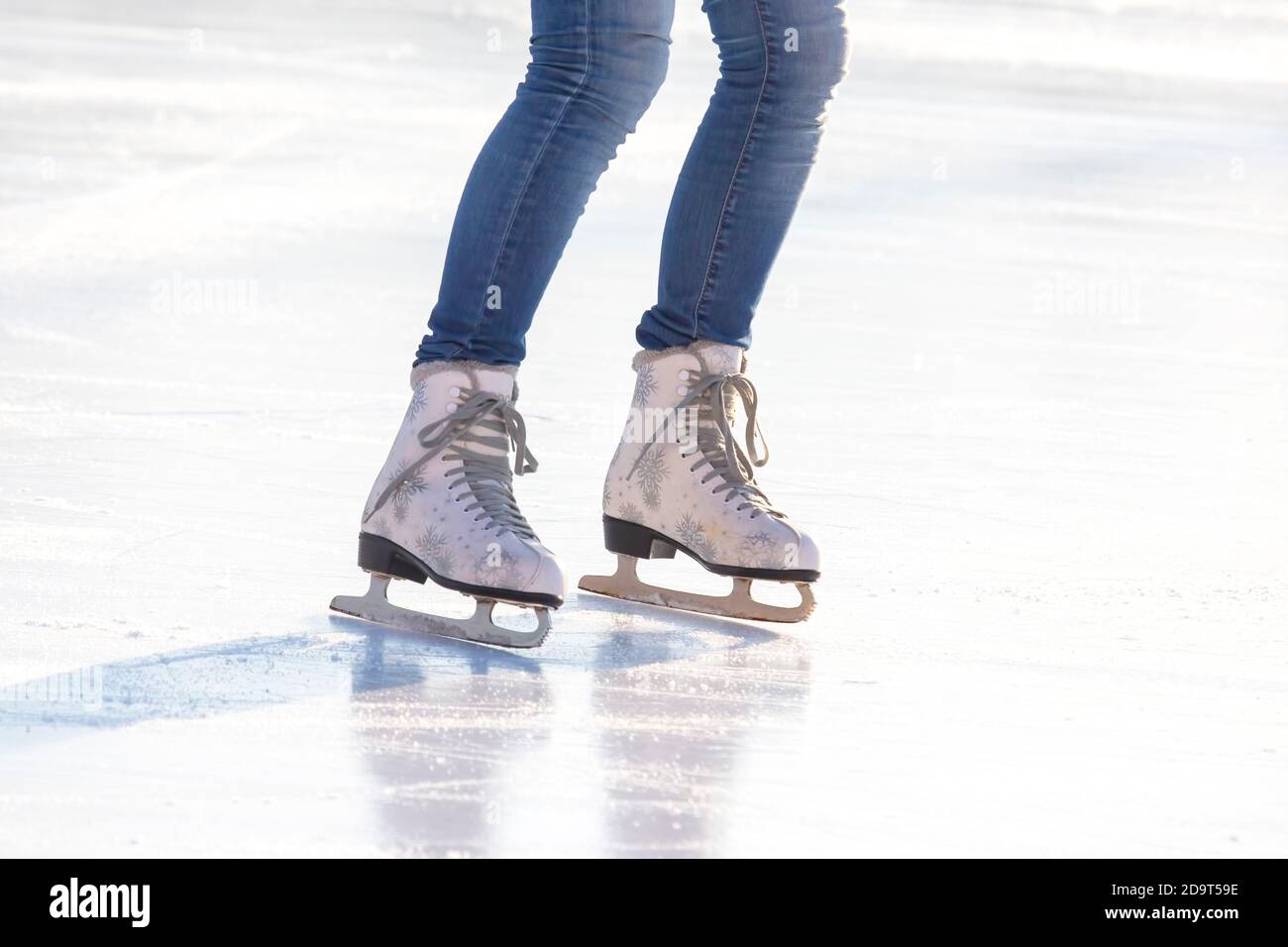 Female legs in skates on an ice rink Stock Photo - Alamy