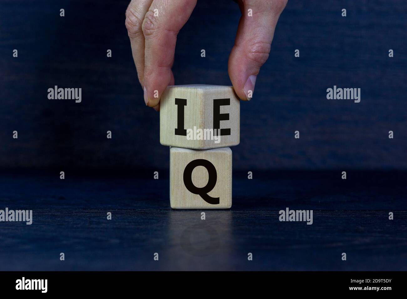 Hand flips a cube and changes the expression 'IQ - intelligence ...