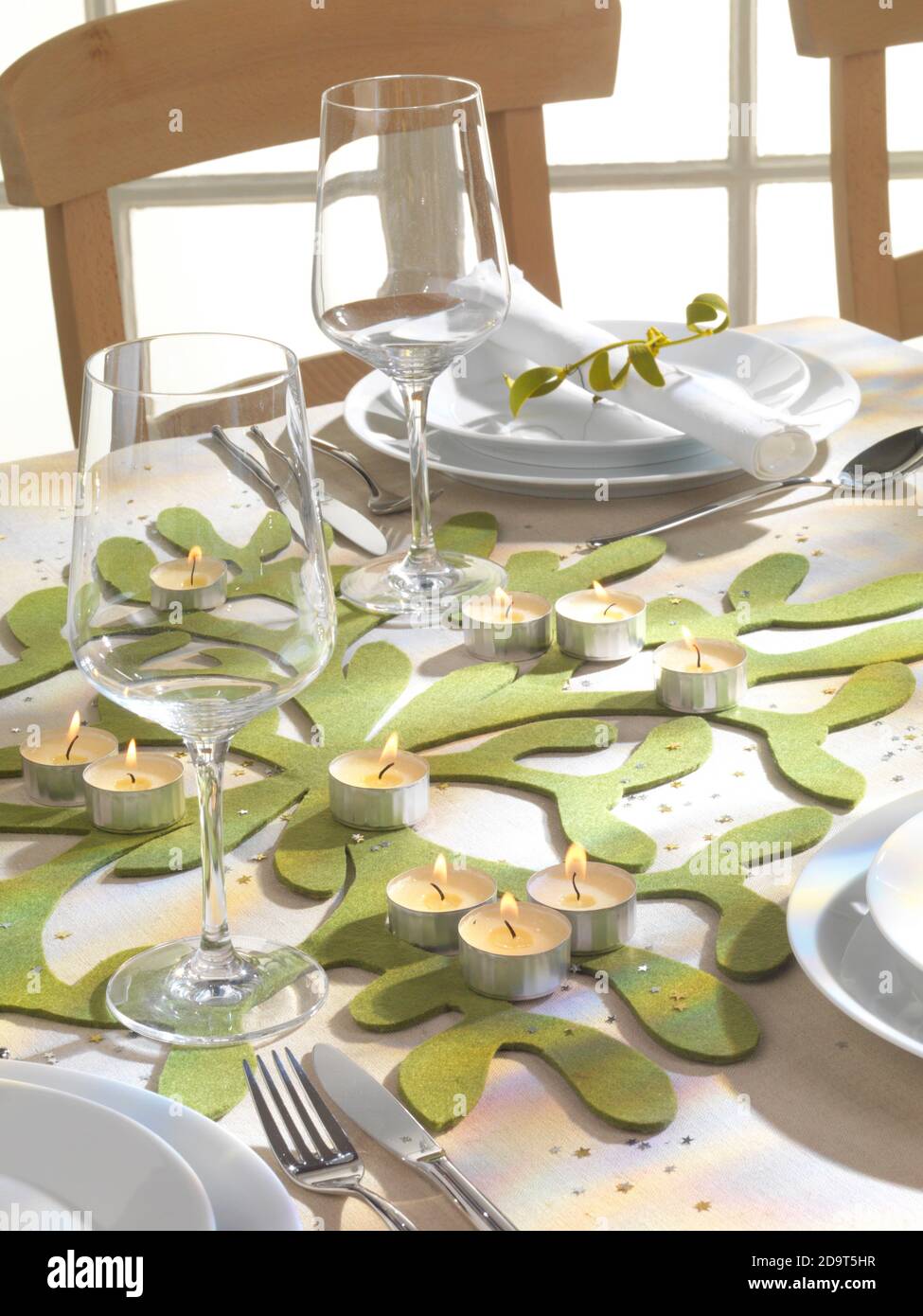 Table with mistletoes made of felt, tea candles and mistletoe berries ...