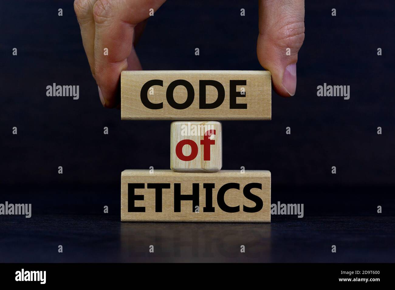 Male hand placing a block with word 'code' on blocks tower with words ...