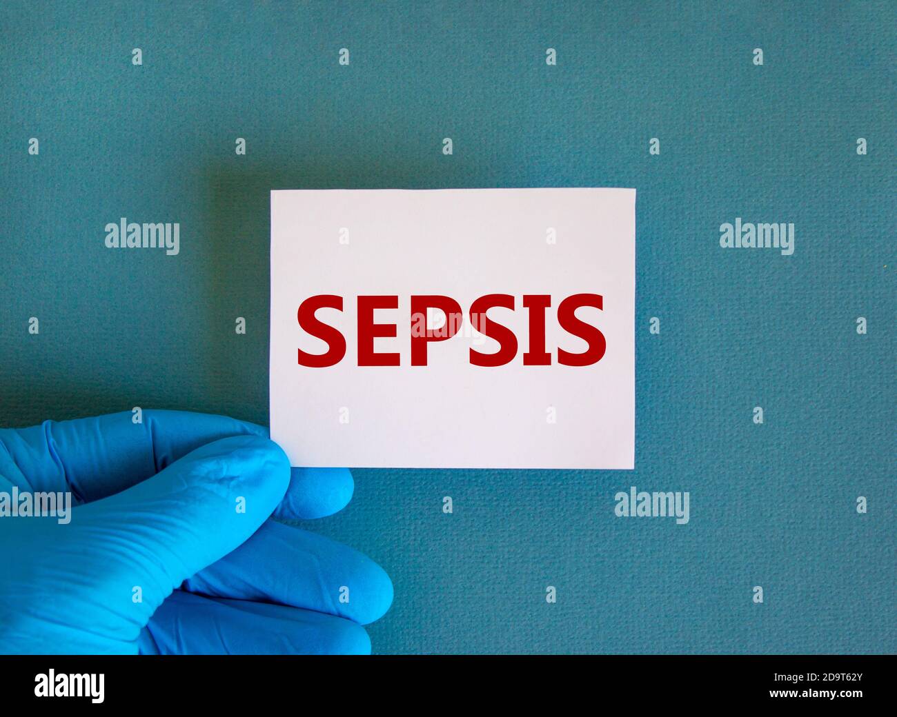 Hand in blue glove with white card. Concept word 'sepsis'. Medical ...