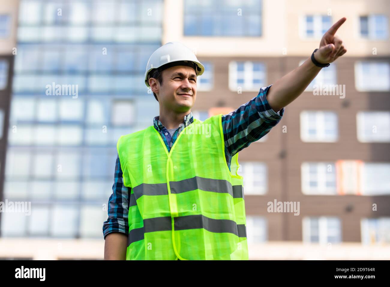 Builder pointed side on at construction site Stock Photo - Alamy