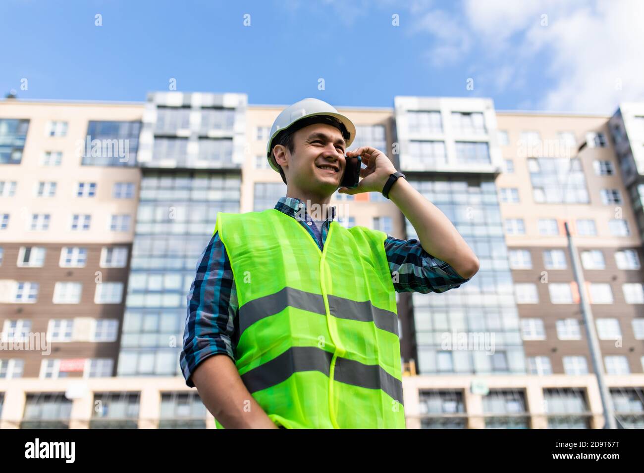 Construction worker activity with mobile phone under new building Stock ...