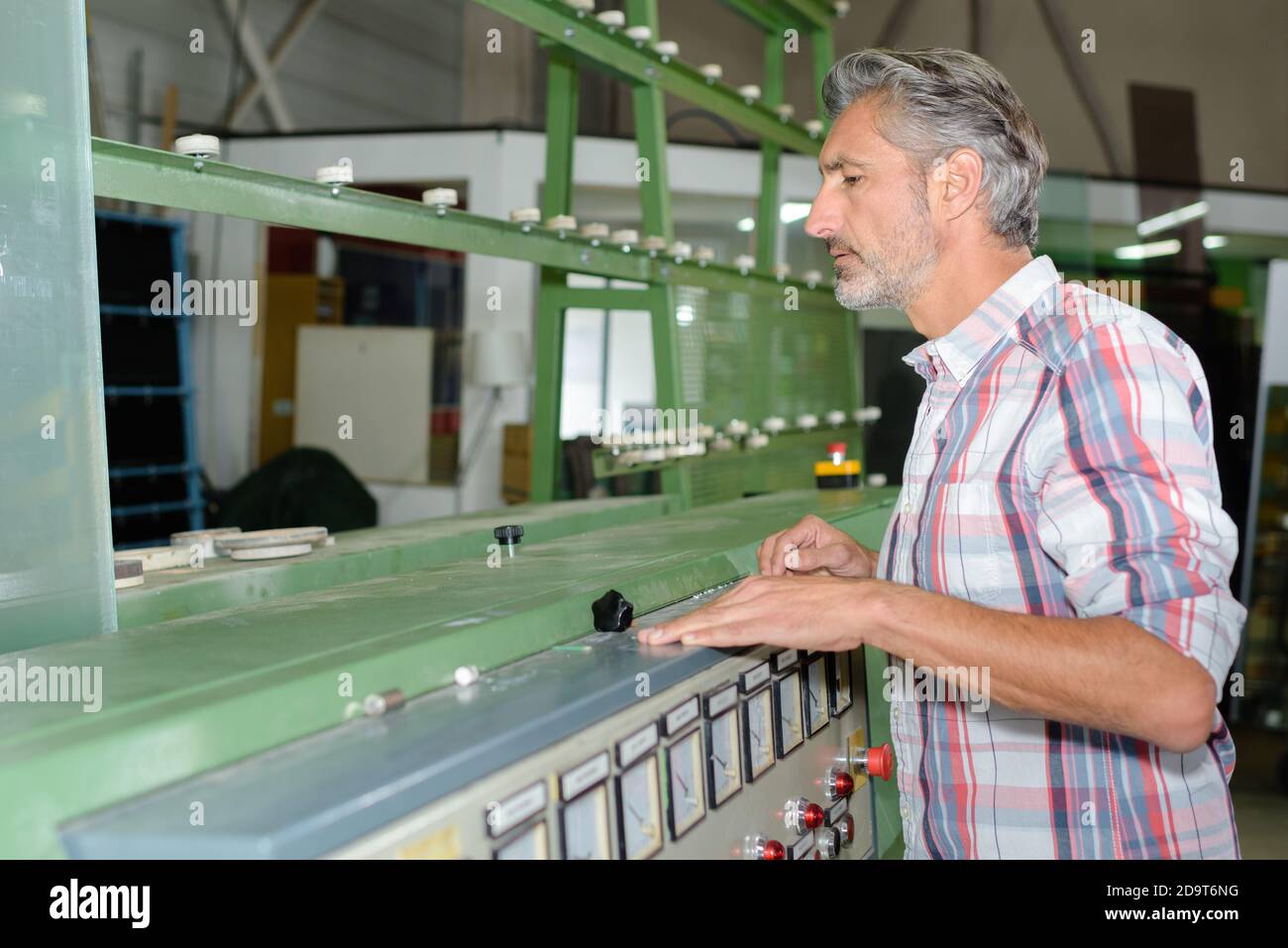 worker stood at controls of large industrial machine Stock Photo - Alamy