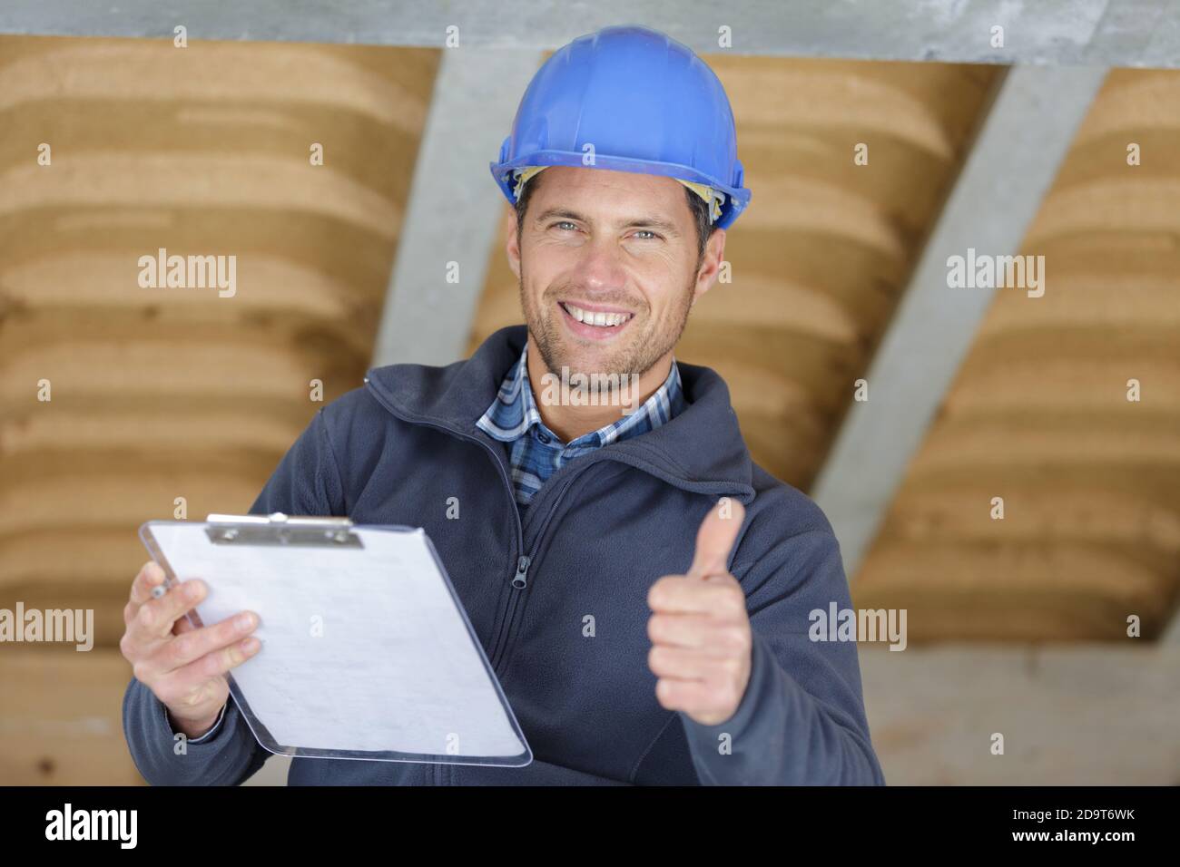 optimistic worker builder man posing showing thumb up Stock Photo - Alamy