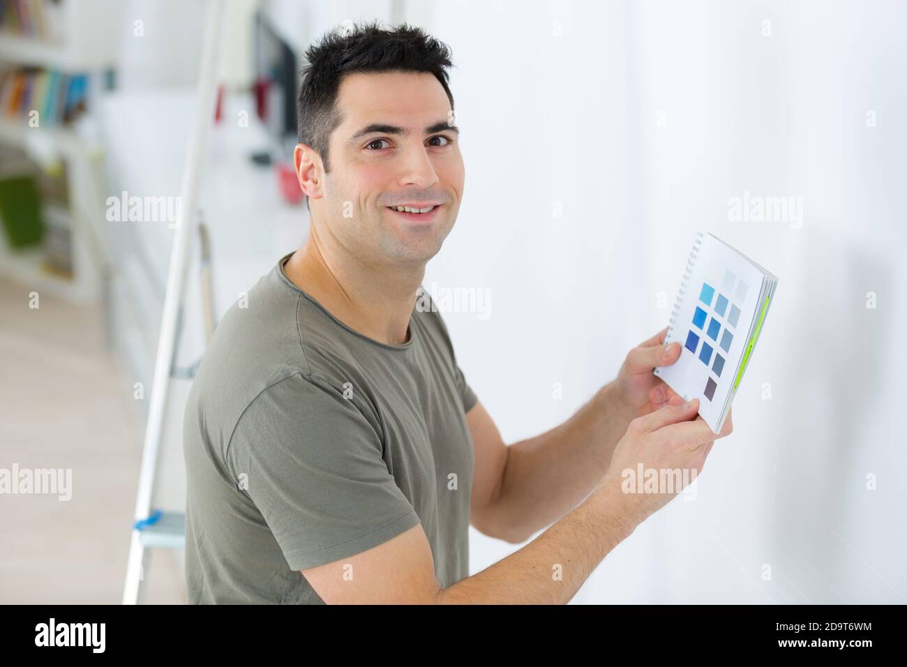 man picking the right shade of blue for his wall Stock Photo - Alamy