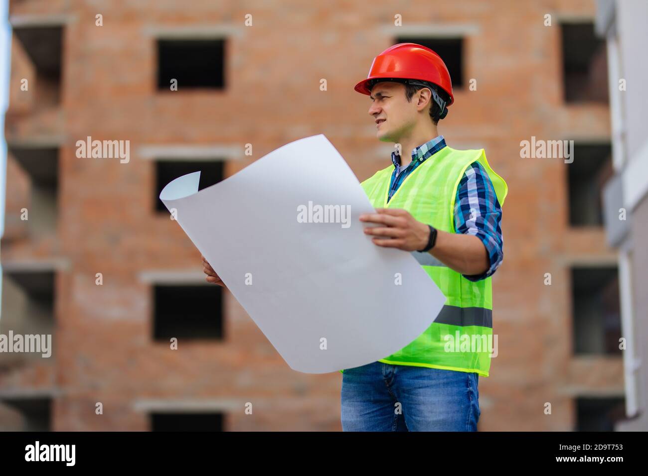 View of an Engineer worker checking plan on construction site Stock ...
