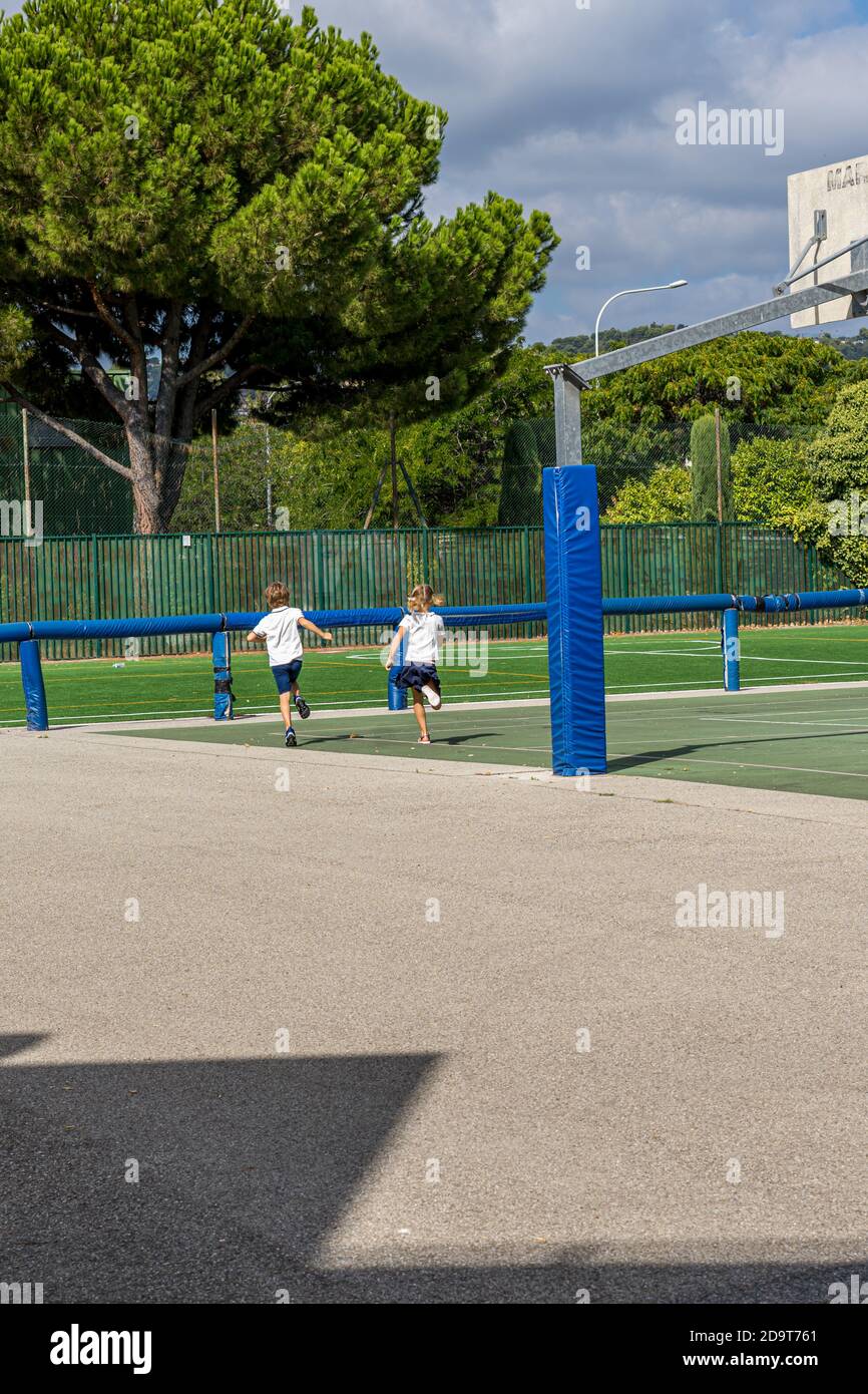 Elementary school kids having fun in school playground. Girl and boy ...