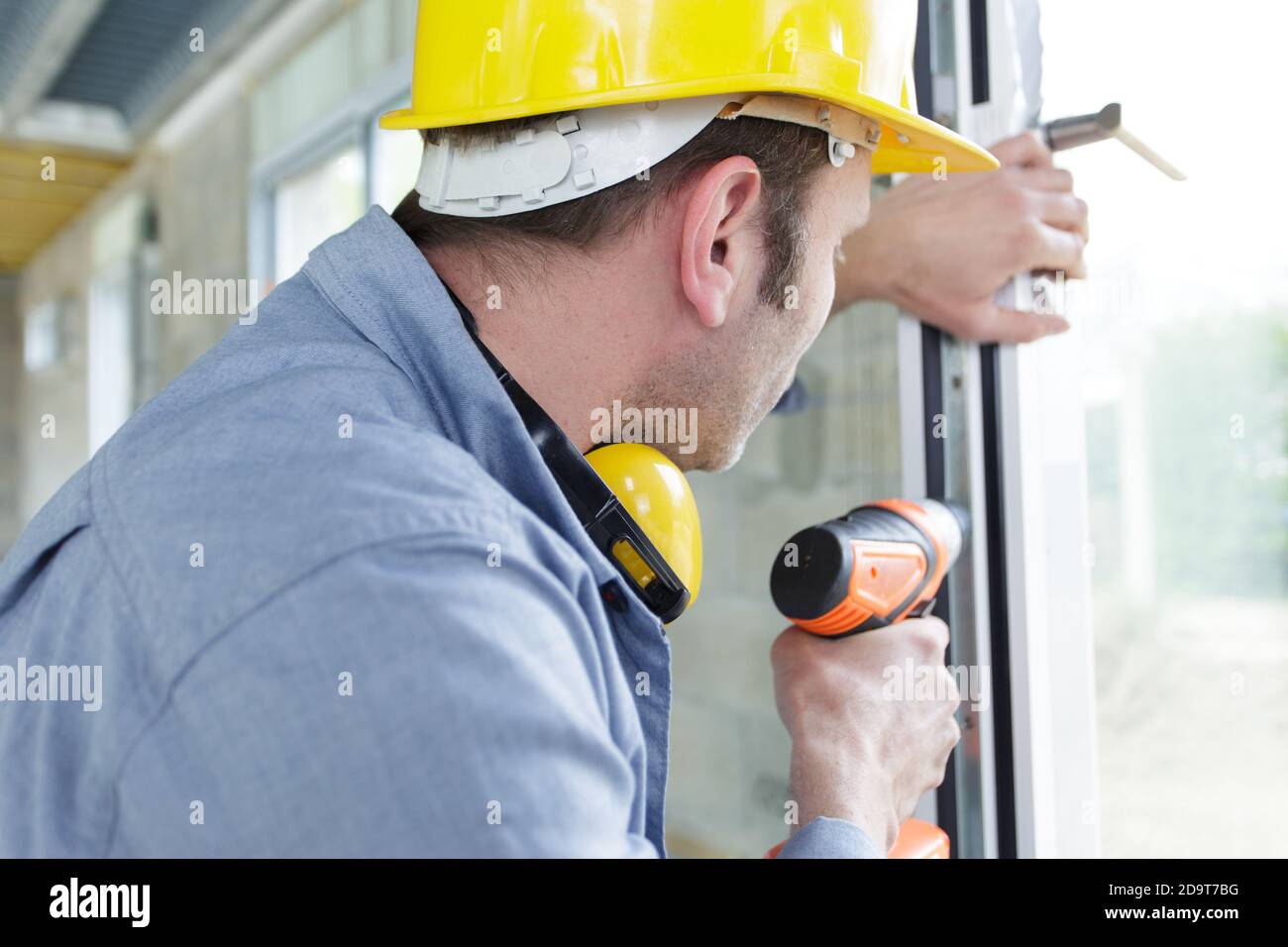 a man is installing a window Stock Photo - Alamy