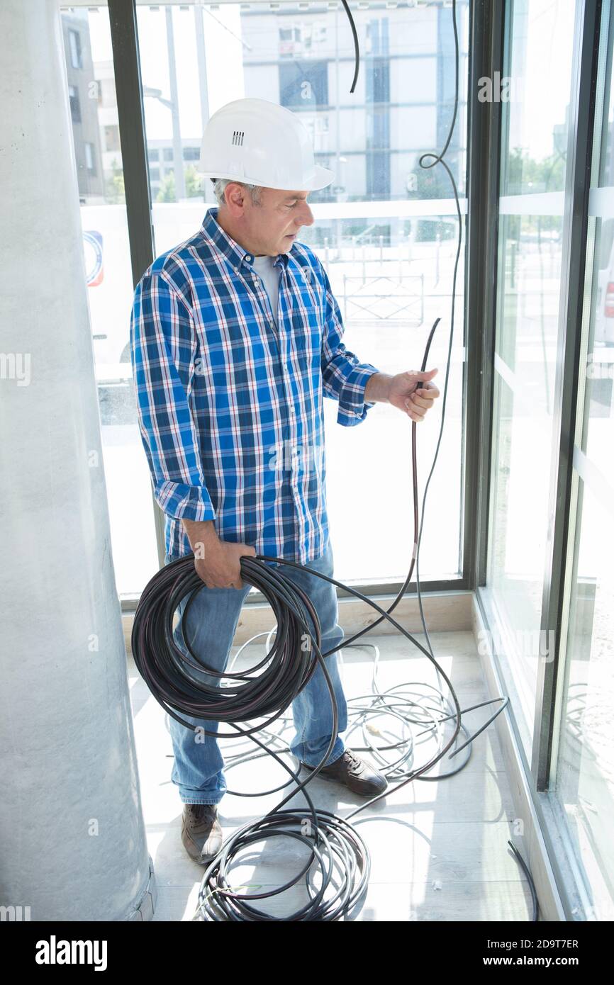 Man holding coiled cable hi-res stock photography and images - Alamy