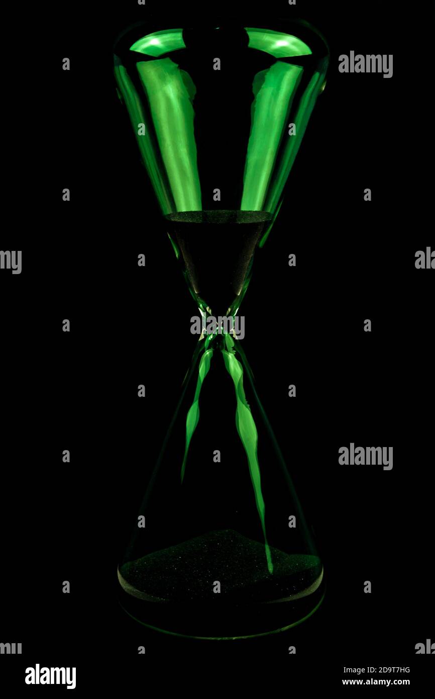 glass hourglass time concept on a black backdrop. Countdown timing ...