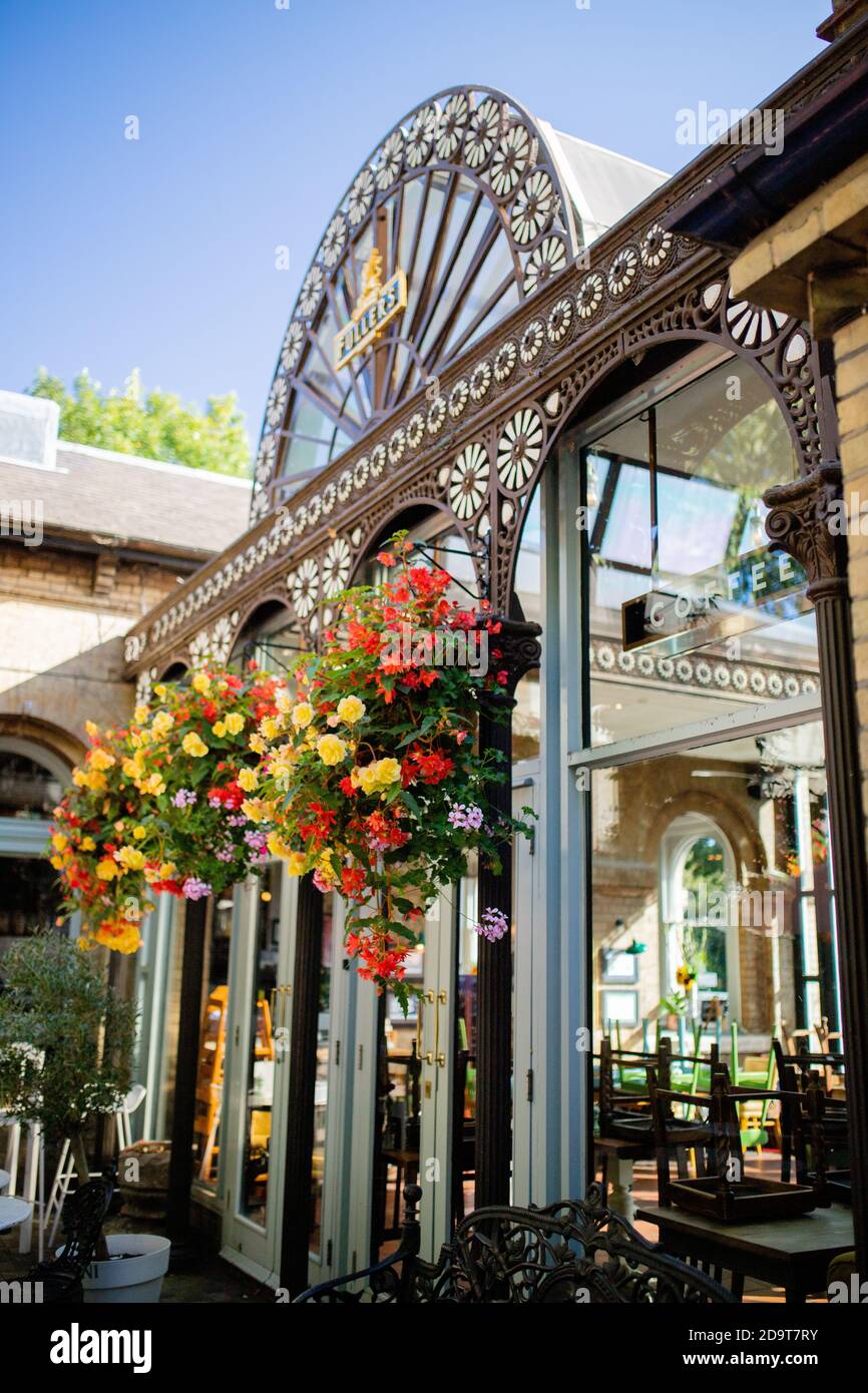 Glass and Metal Arch Over a Cafe Entrance Surrounded by Flowers Stock ...