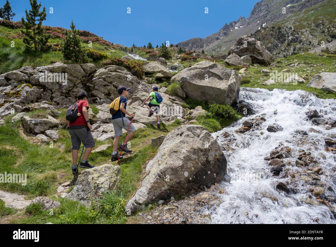 children climbing a mountain next to a river in the pyrenees Stock ...