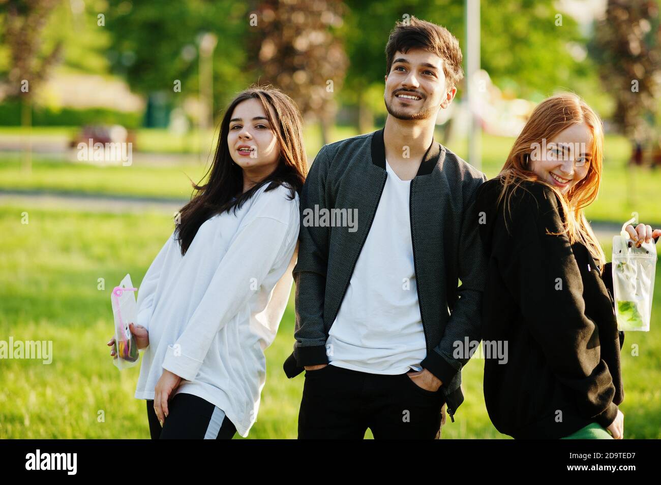 Indian man with two european girls posed outdoor Stock Photo - Alamy