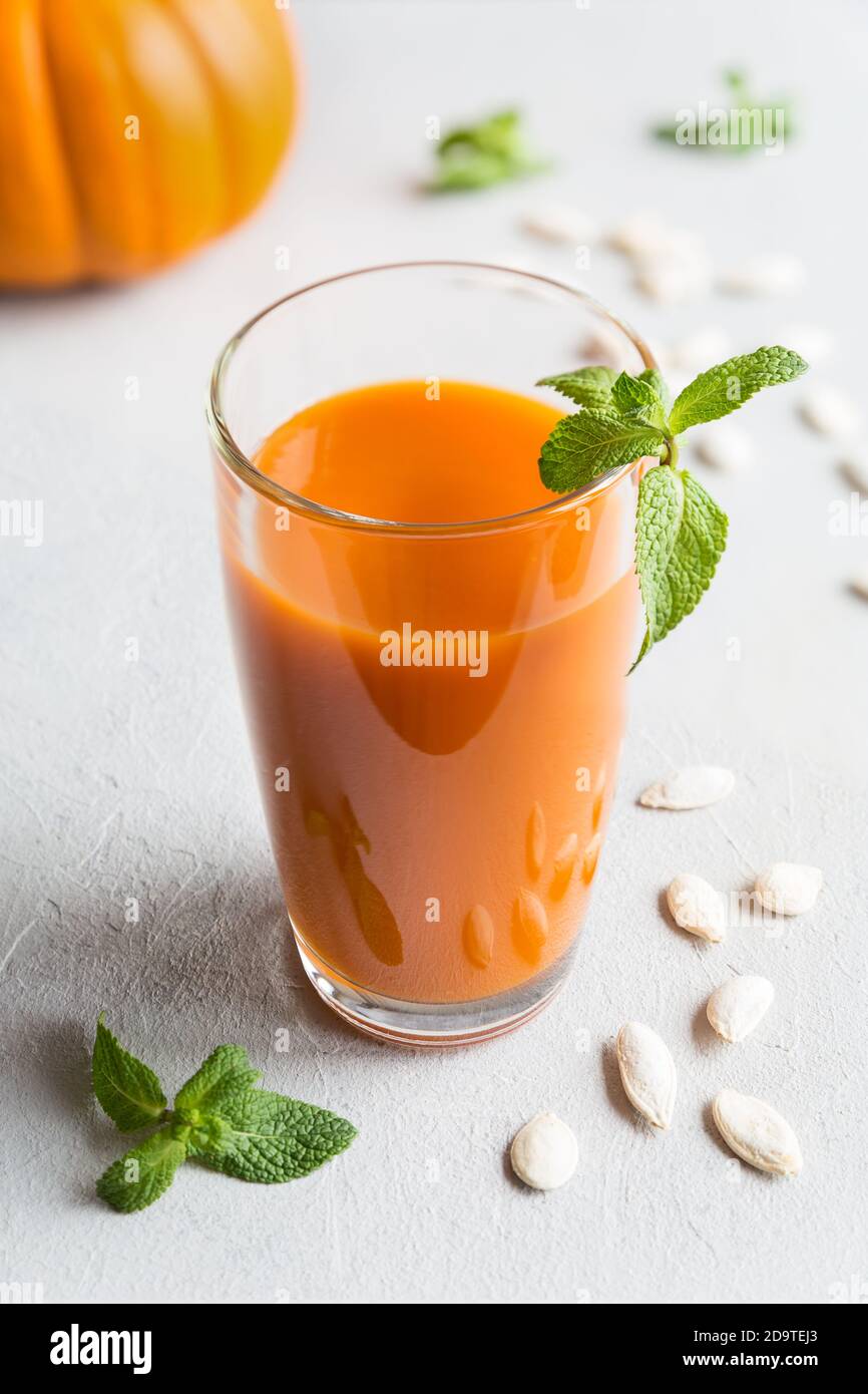 Fresh pumpkin juice in a tall glass decorated with mint leaves and ...