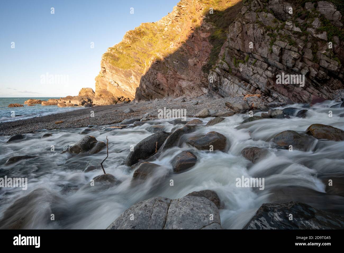 Long exposure of the river Heddon flowing onto the beach at Heddons ...