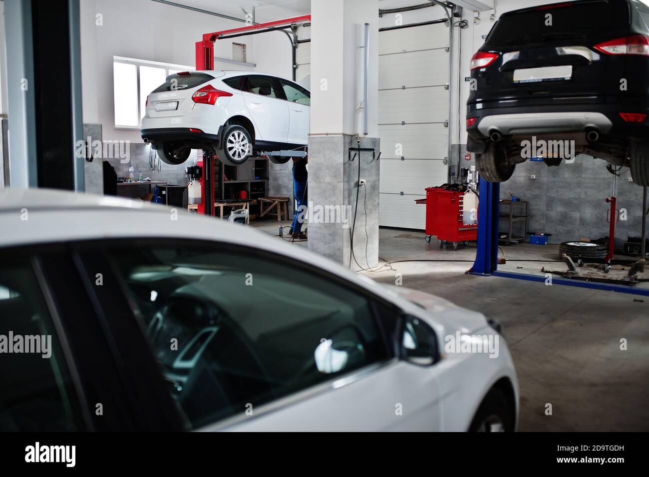 Cars lifting in maintenance at garage service station Stock Photo - Alamy