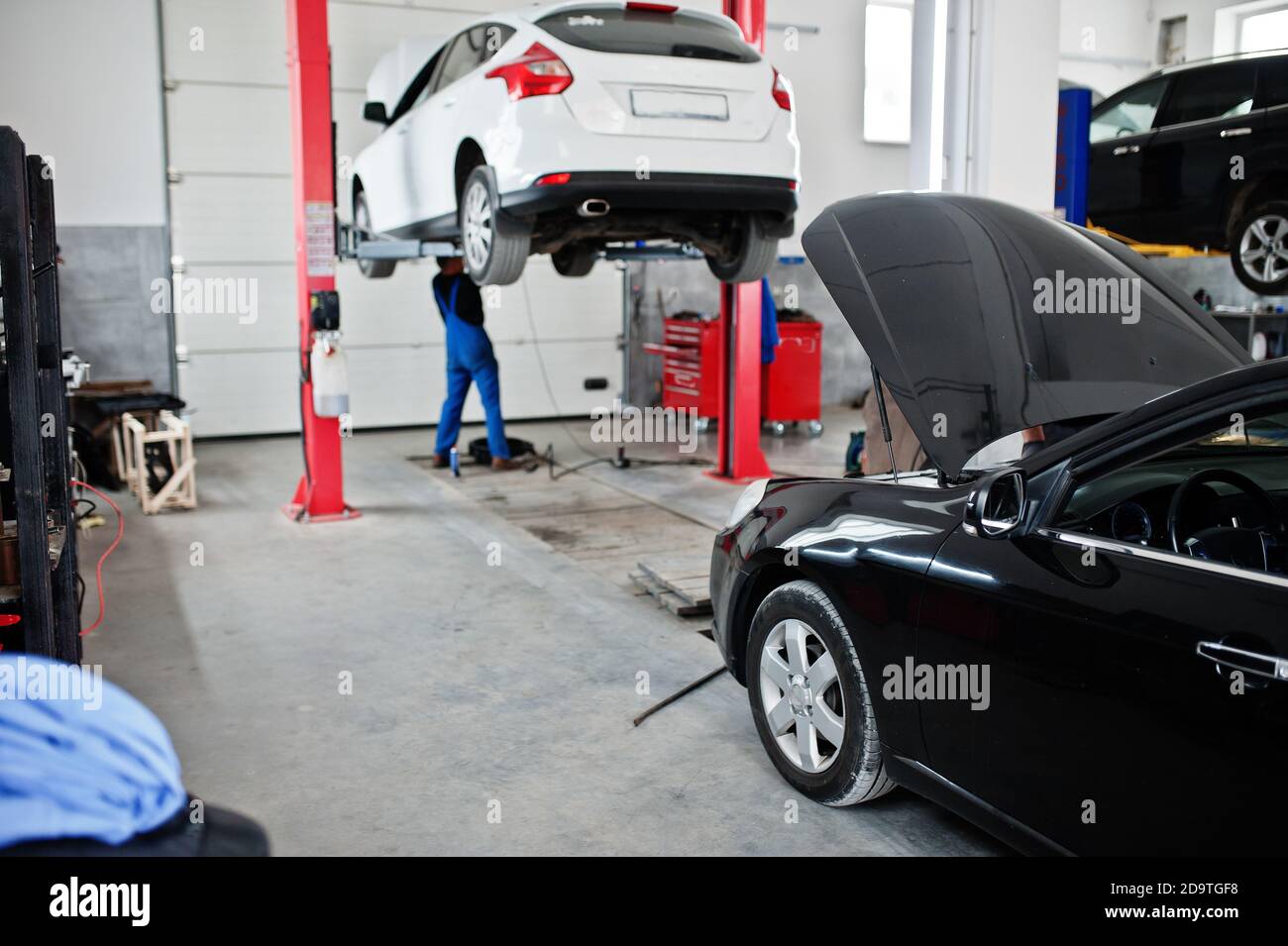 Cars lifting in maintenance at garage service station Stock Photo - Alamy