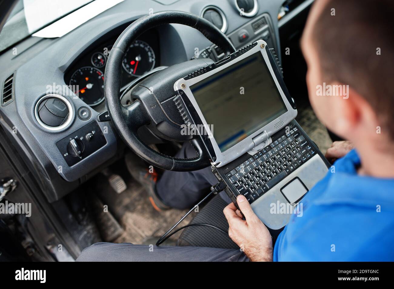 Car repair and maintenance theme. Electric mechanic in uniform working in auto service, making ...