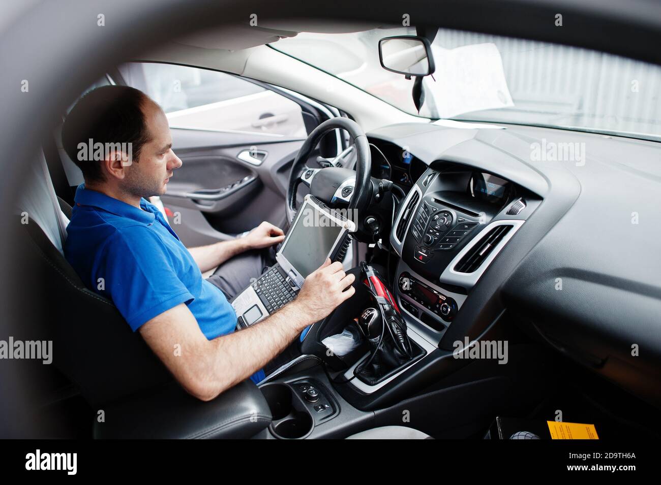 Car repair and maintenance theme. Electric mechanic in uniform working in auto service, making ...