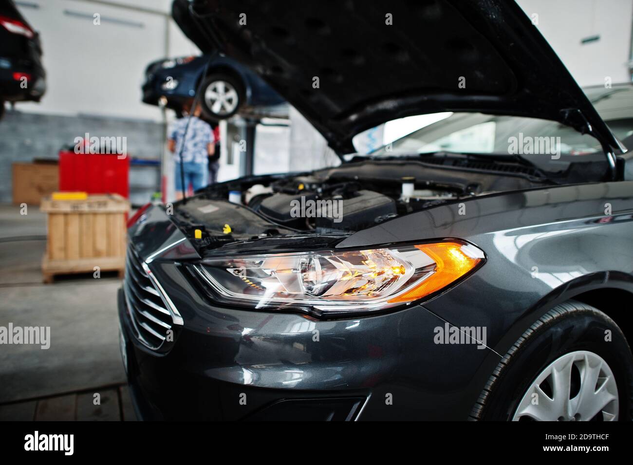 Car repair and maintenance theme. Car open hood engine in auto service ...