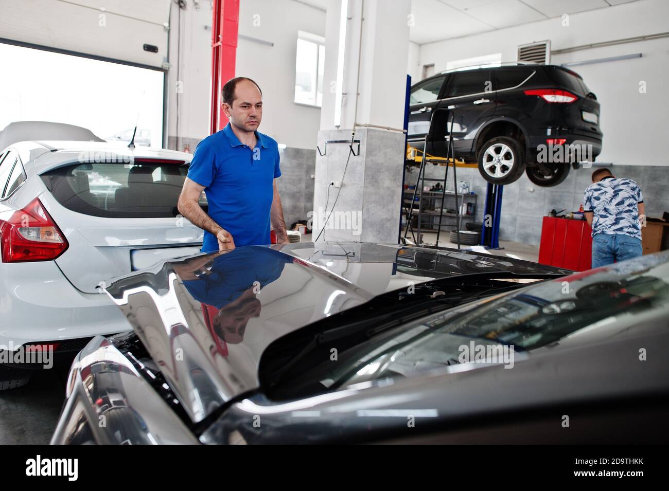 Car repair and maintenance theme. Mechanic in uniform working in auto ...