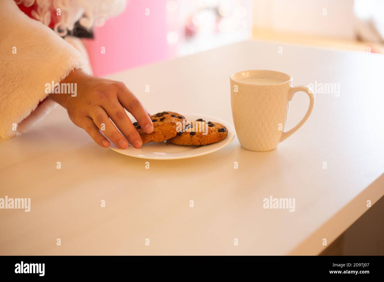 Santa picking cookie and glass of milk at home Stock Photo - Alamy